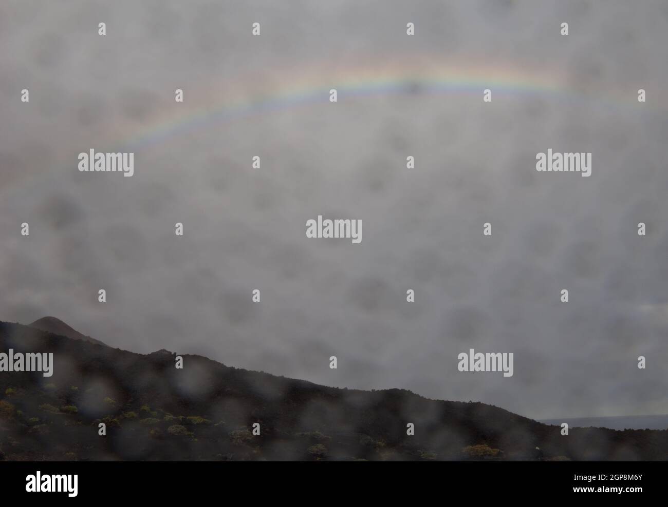 Rainbow in a rainy day over a volcanic landscape. Teneguia Volcanoes ...