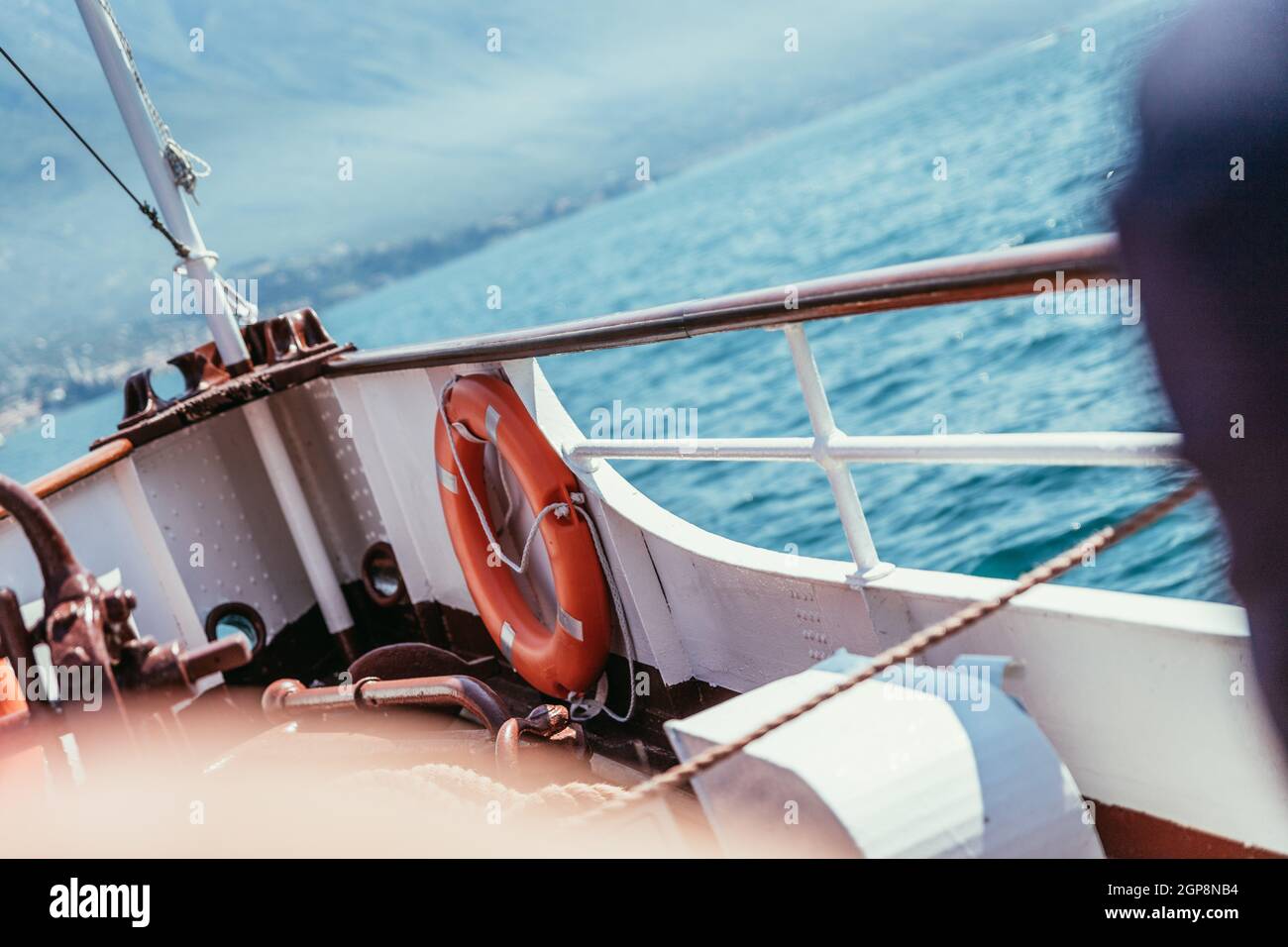 Bow of a boat with safety buoy on a boat tour. Blue water and mountain ...