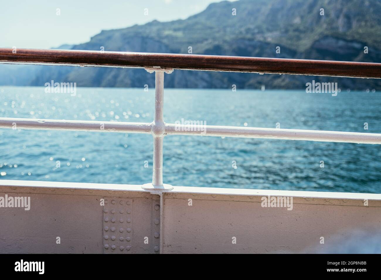 Railing of a boat, boat tour. Blue water and mountain range, Lago di ...