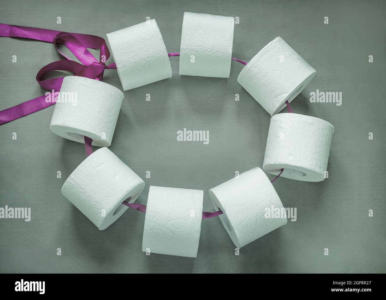 Rolls of white toilet paper are connected with a ribbon in a bundle ...
