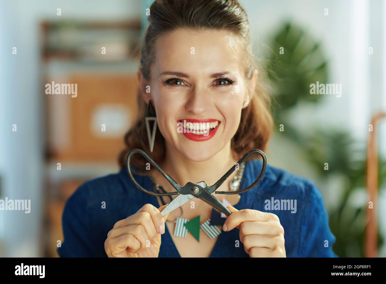 Portrait of happy elegant small business owner woman with scissors in ...