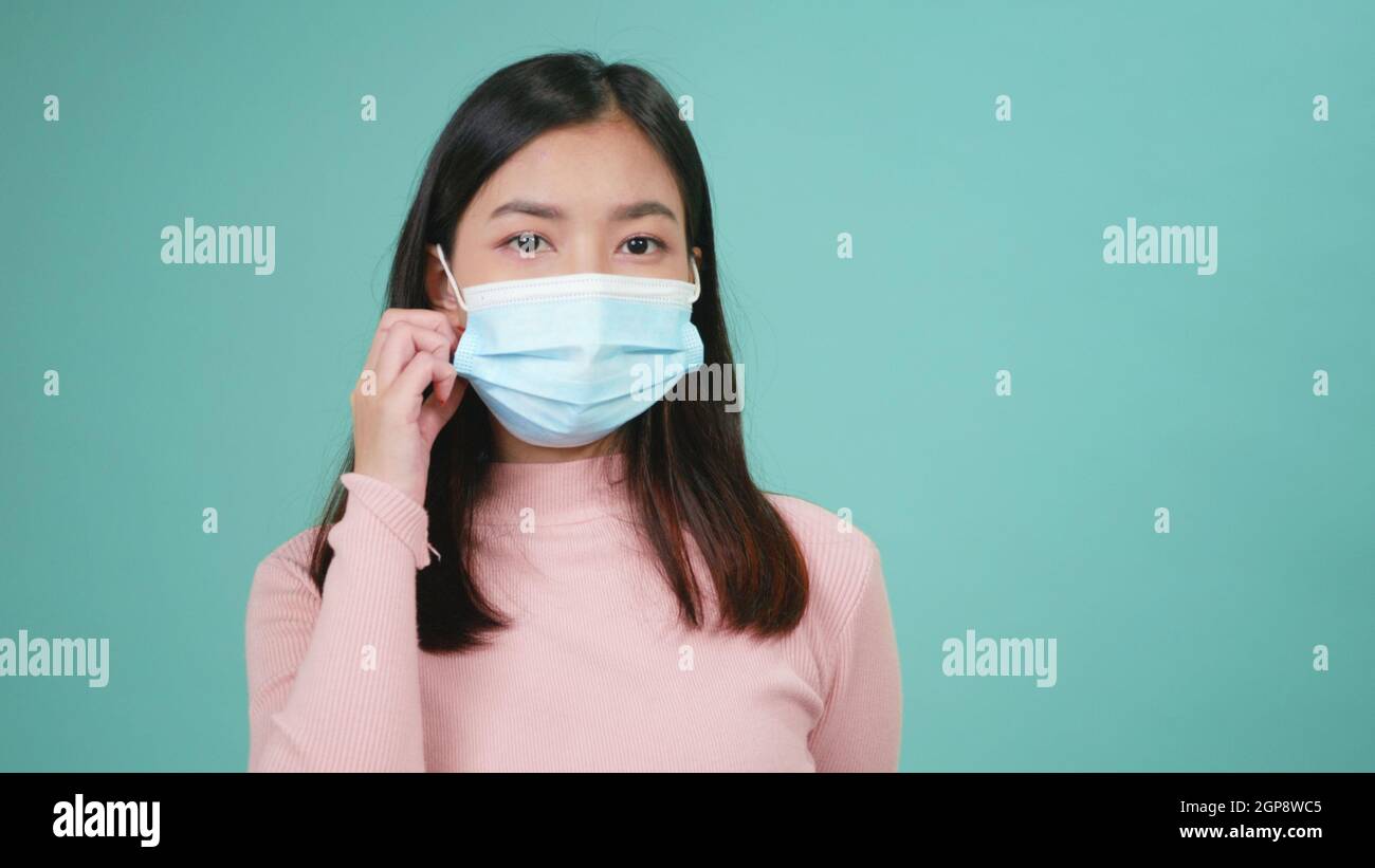 Portrait young Asian happy beautiful woman take off protective face ...