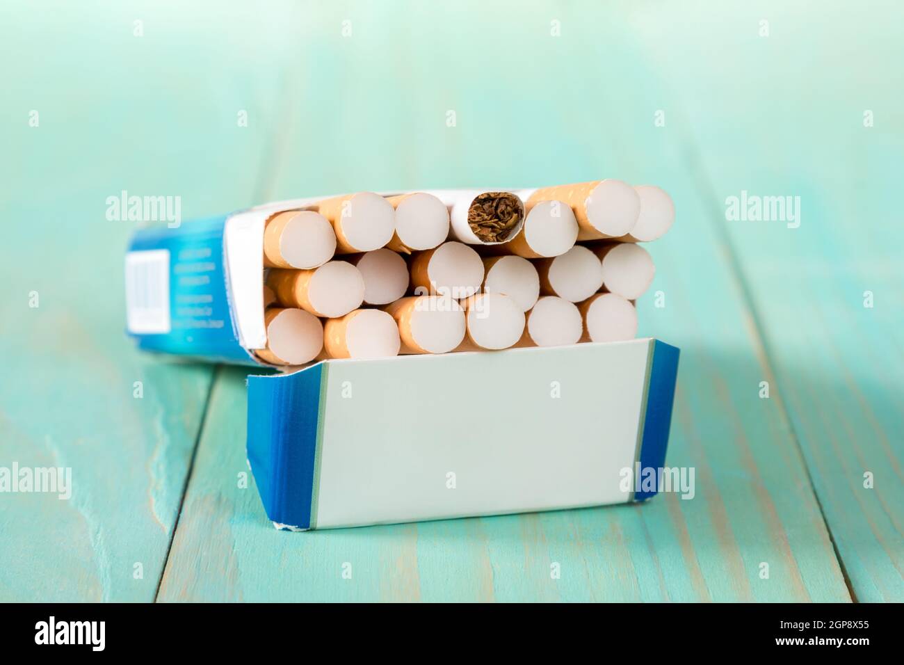 Open pack of cigarettes lying on a blue wooden background Stock Photo ...