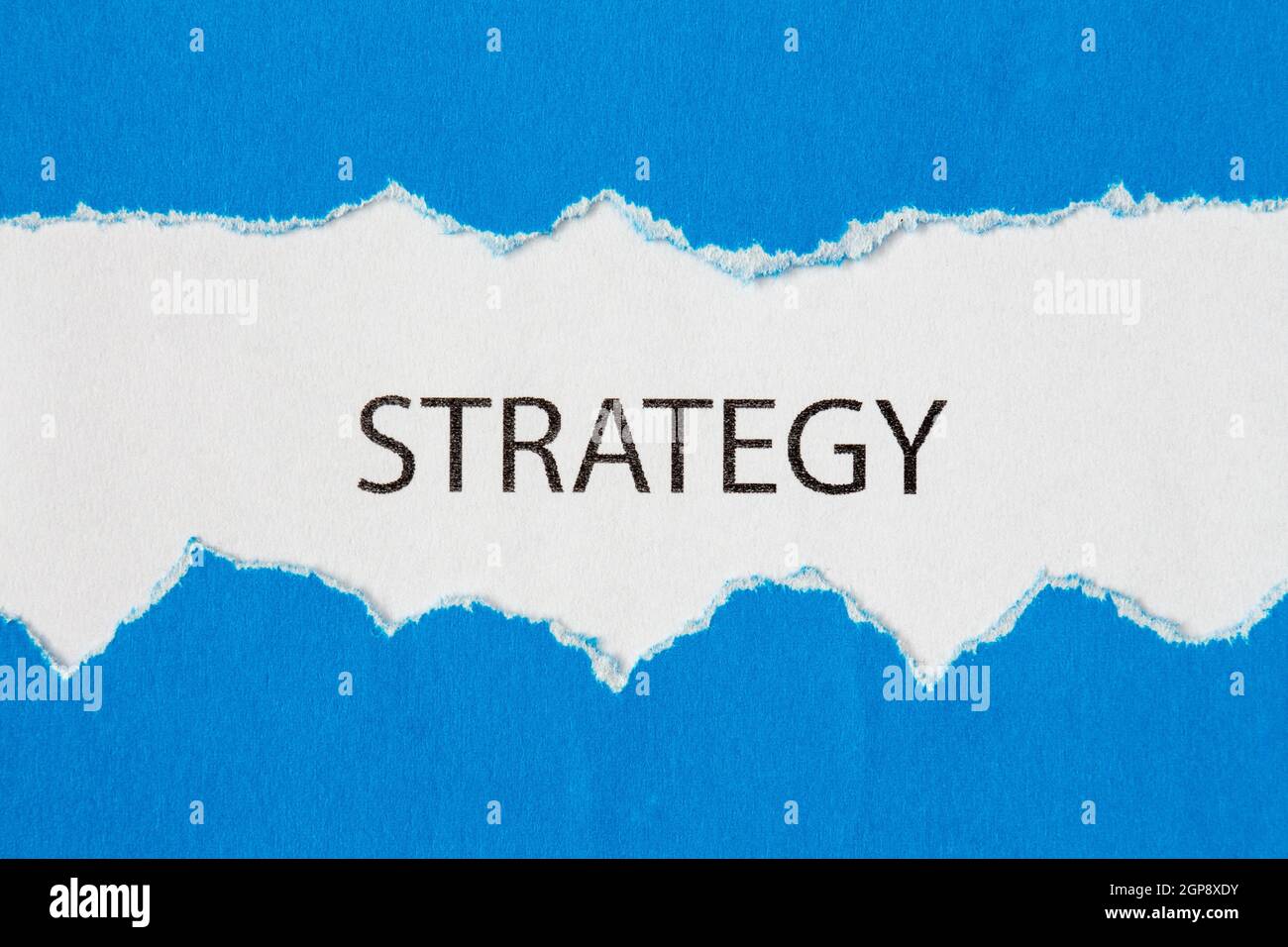 The word STRATEGY appearing behind torn blue paper Stock Photo - Alamy