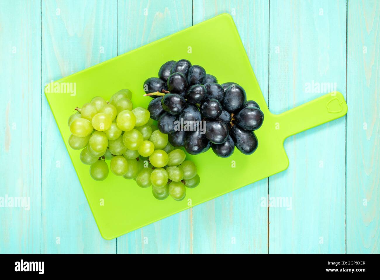 Plastic cutting board with green and blue grapes Stock Photo - Alamy