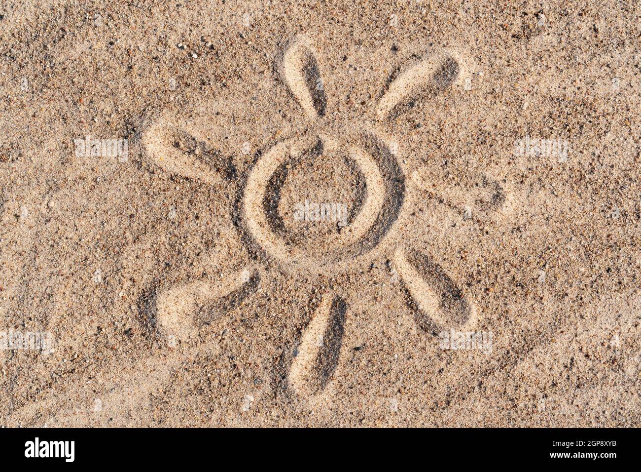 Simple sun drawing in the sand on the beach Stock Photo - Alamy
