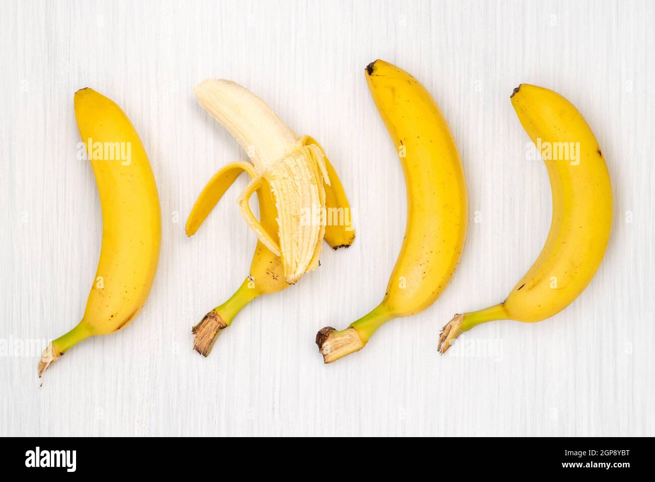 Four bananas on wooden table. Top view Stock Photo - Alamy