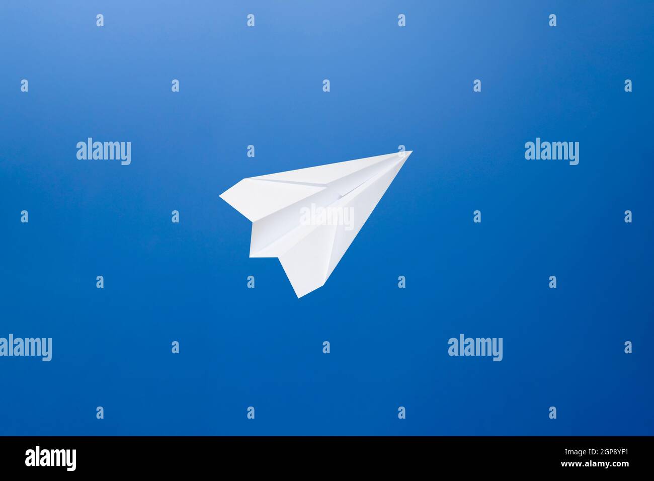 White paper airplane on a blue sky background. The symbol of freedom ...