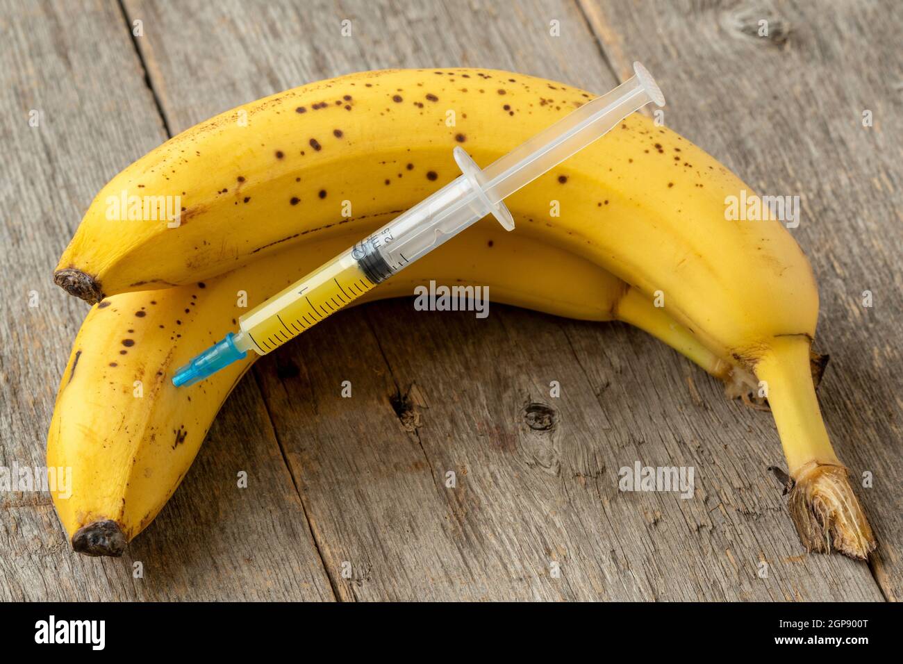 Syringe and banana bunch. Concept for genetically modified food and ...