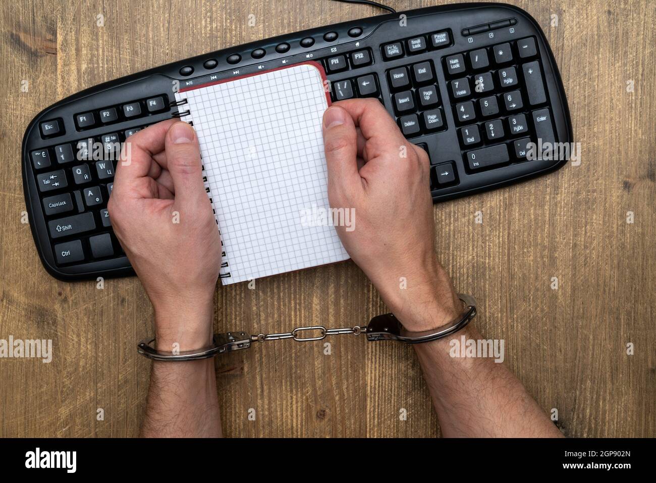 Hacker concept, punishment for cybercrime with hands in handcuffs above ...