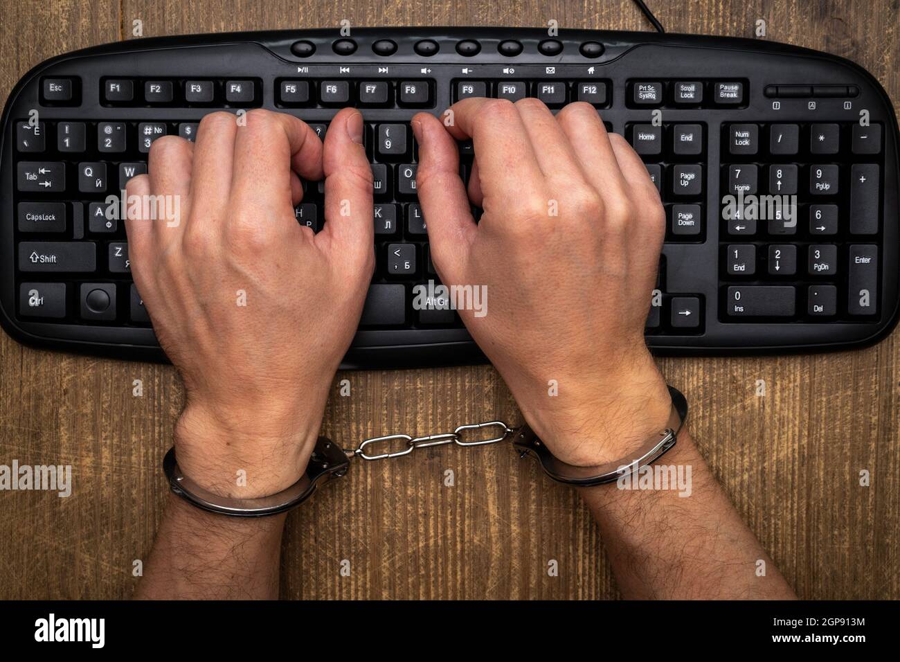 Hacker concept, punishment for cybercrime with hands in handcuffs above ...