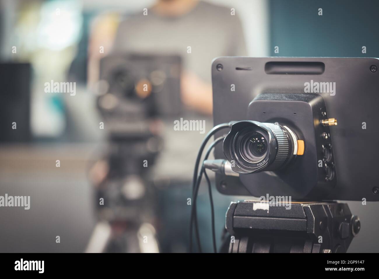 Film camera on a tripod in a television broadcasting studio, spotlights ...