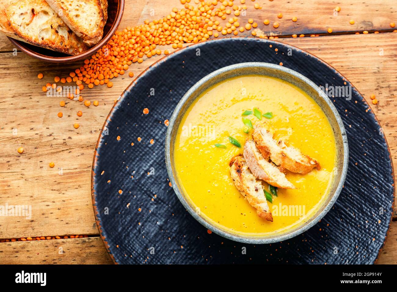Plate of vegetarian red lentil soup on wooden table Stock Photo - Alamy