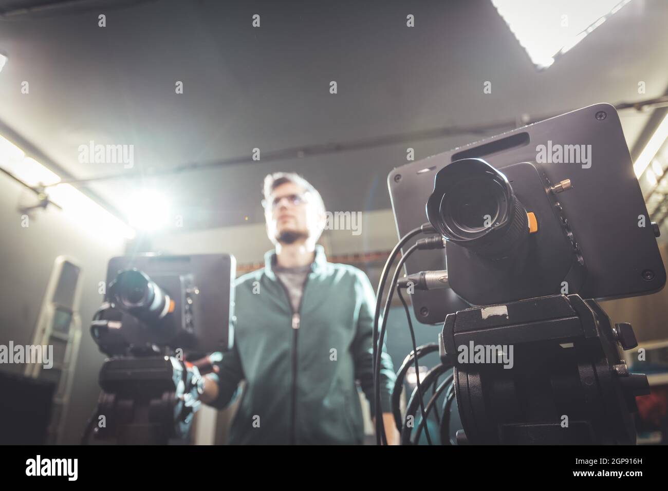 Male cameraman is operating a film camera in a television recording ...