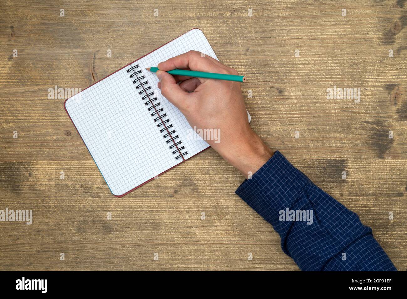 Hand writing in open notebook on table Stock Photo - Alamy