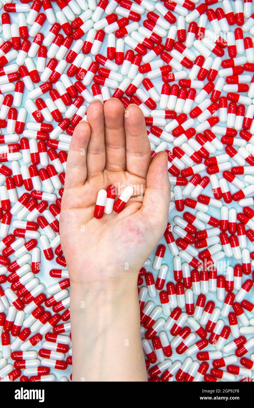 hands holding red and white capsules for medication, vitamin or drugs ...