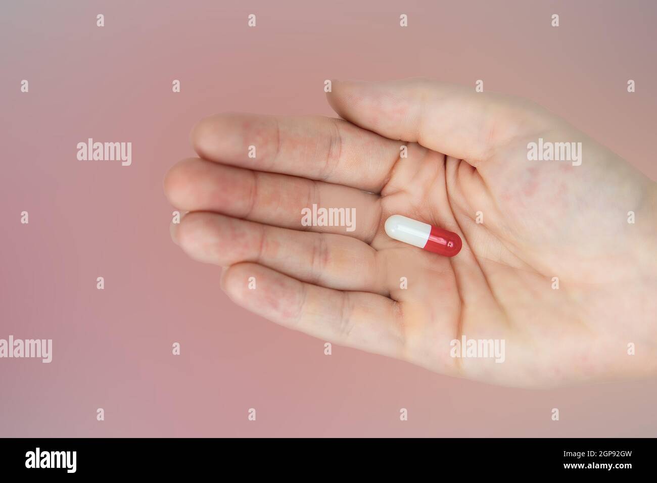 hands holding red and white capsules for medication, vitamin or drugs ...