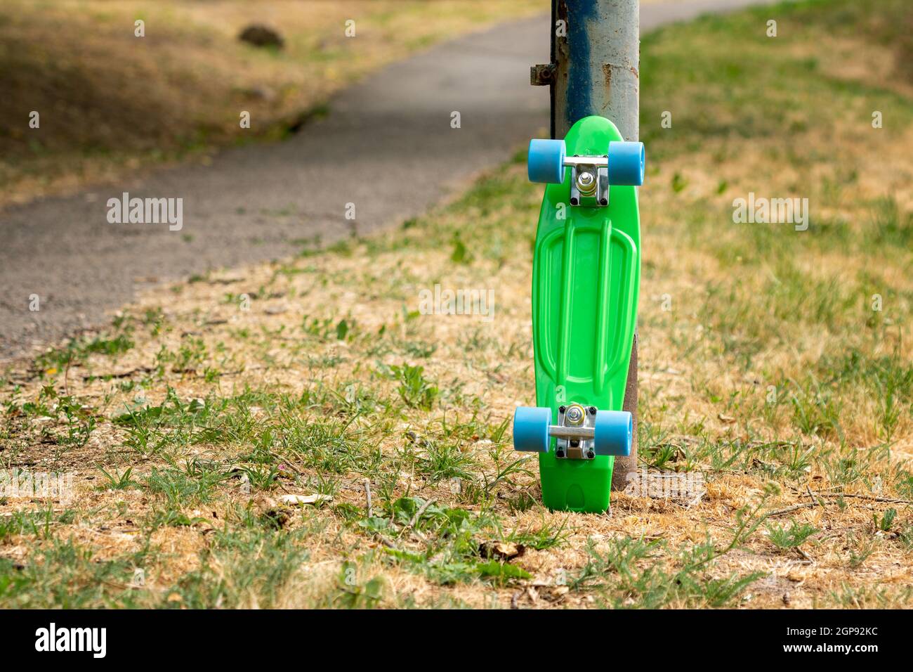 Abandoned skateboard at park near the asphalt pathway Stock Photo - Alamy