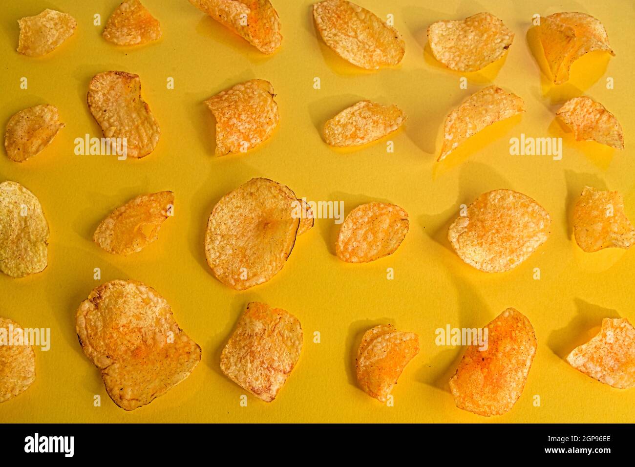Close-up of potato chips or crisps on pastel yellow background. Cinema ...