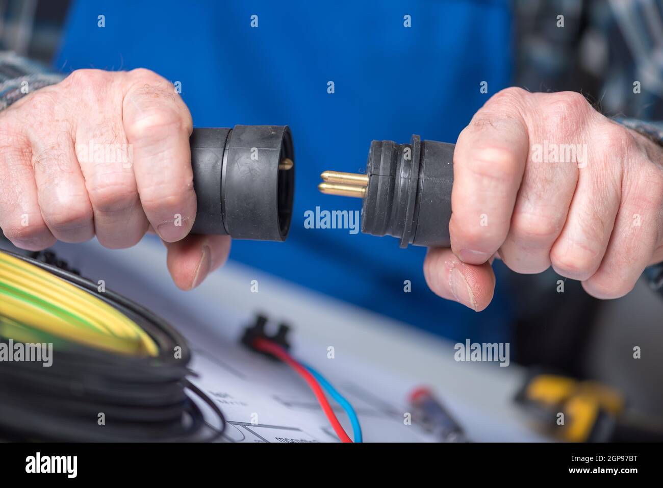 Electrician hands holding electrical plugs Stock Photo - Alamy