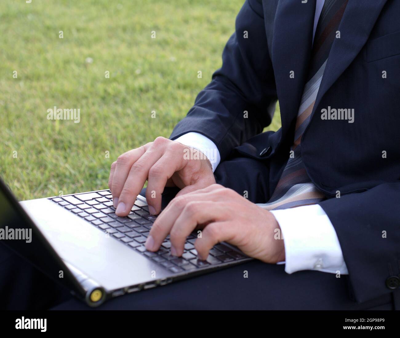 Man in suit works with his computer Stock Photo - Alamy