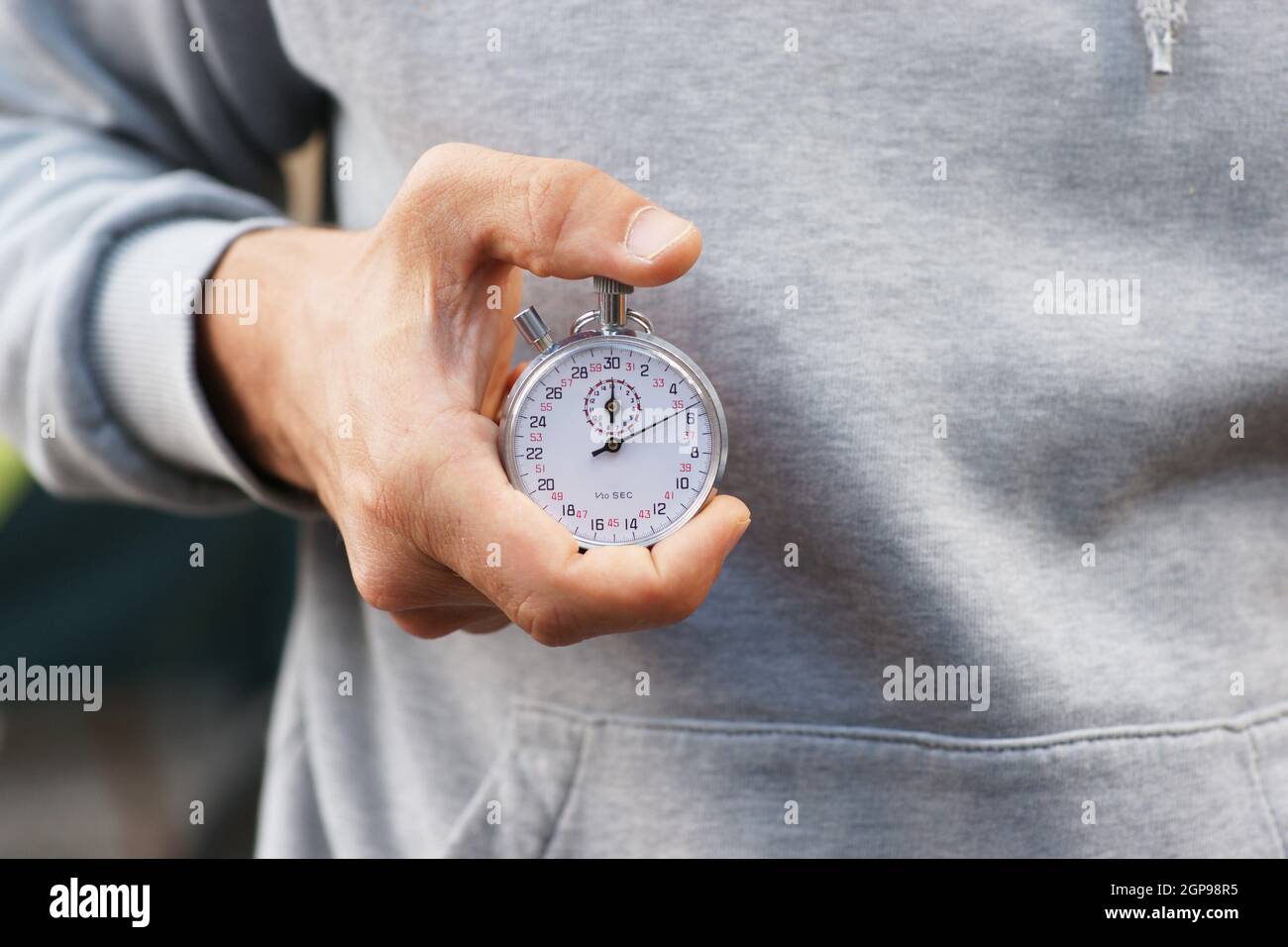 Coach measures time with stopwatch Stock Photo - Alamy