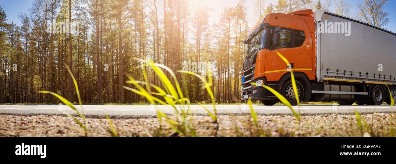 Lorry on asphalt road on spring day. Truck moving on the highway in ...