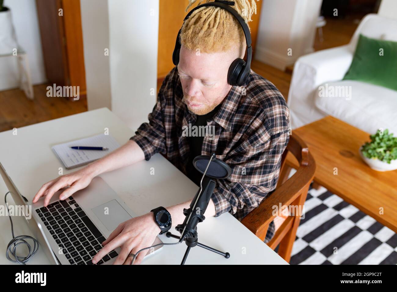 Happy albino african american man with dreadlocks working from home and ...