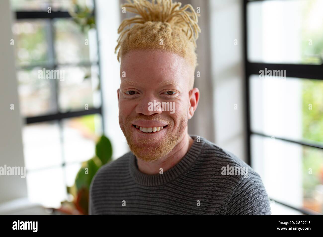 Portrait of happy african american man with dreadlocks in living room ...