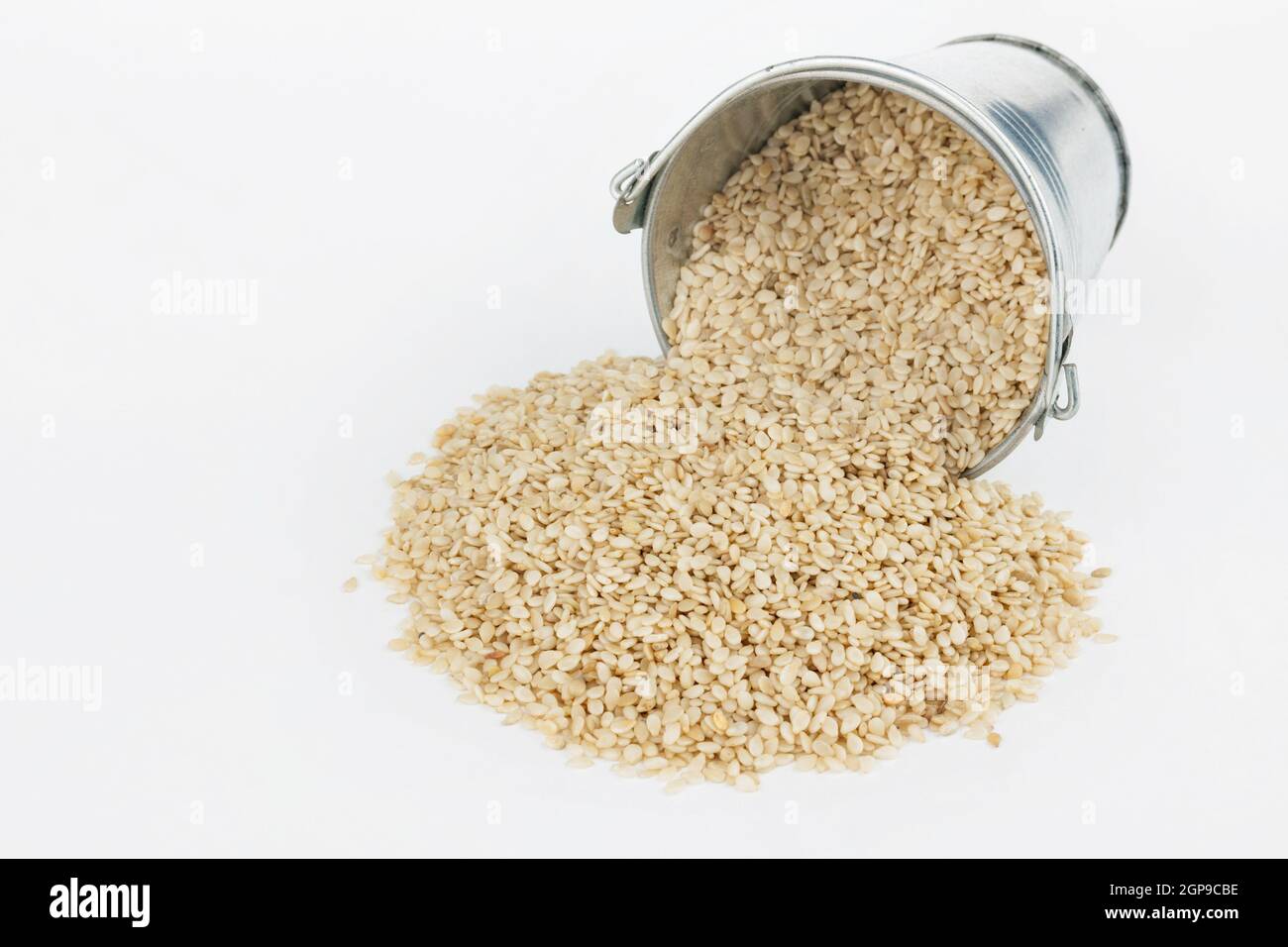 Sesame seeds spilling out of bucket, on a white background Stock Photo ...