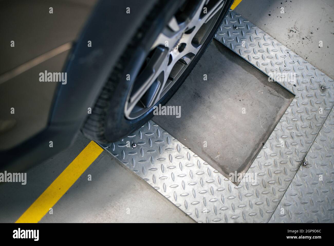 Car mechanic changind tires of a car in a repair shop/car garage ...