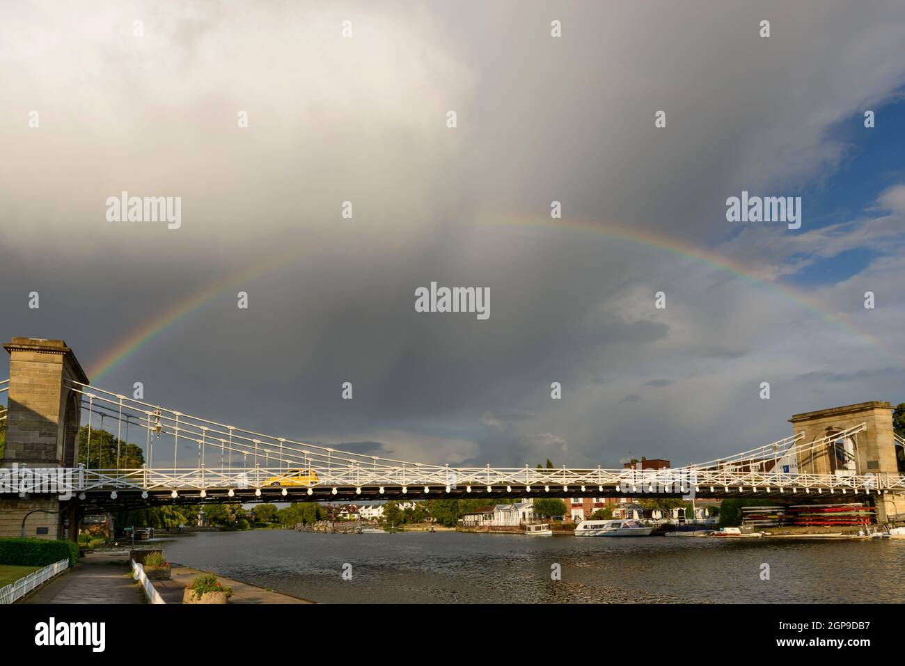 old suspension bridge on river Thames , shot in bright light after ...