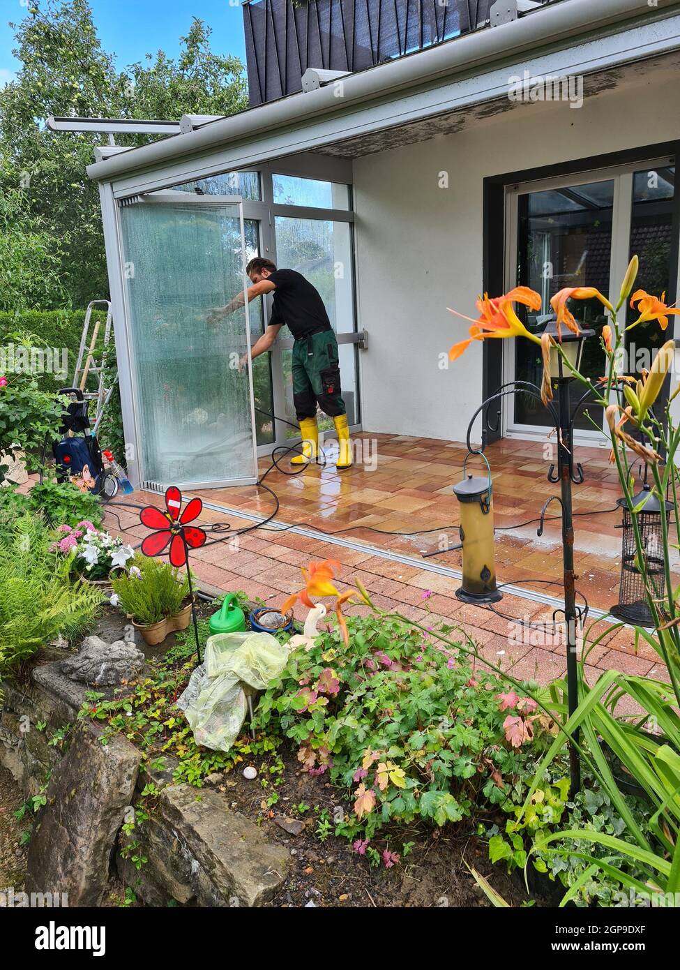 Man power washing conservatory roof and windows Stock Photo - Alamy