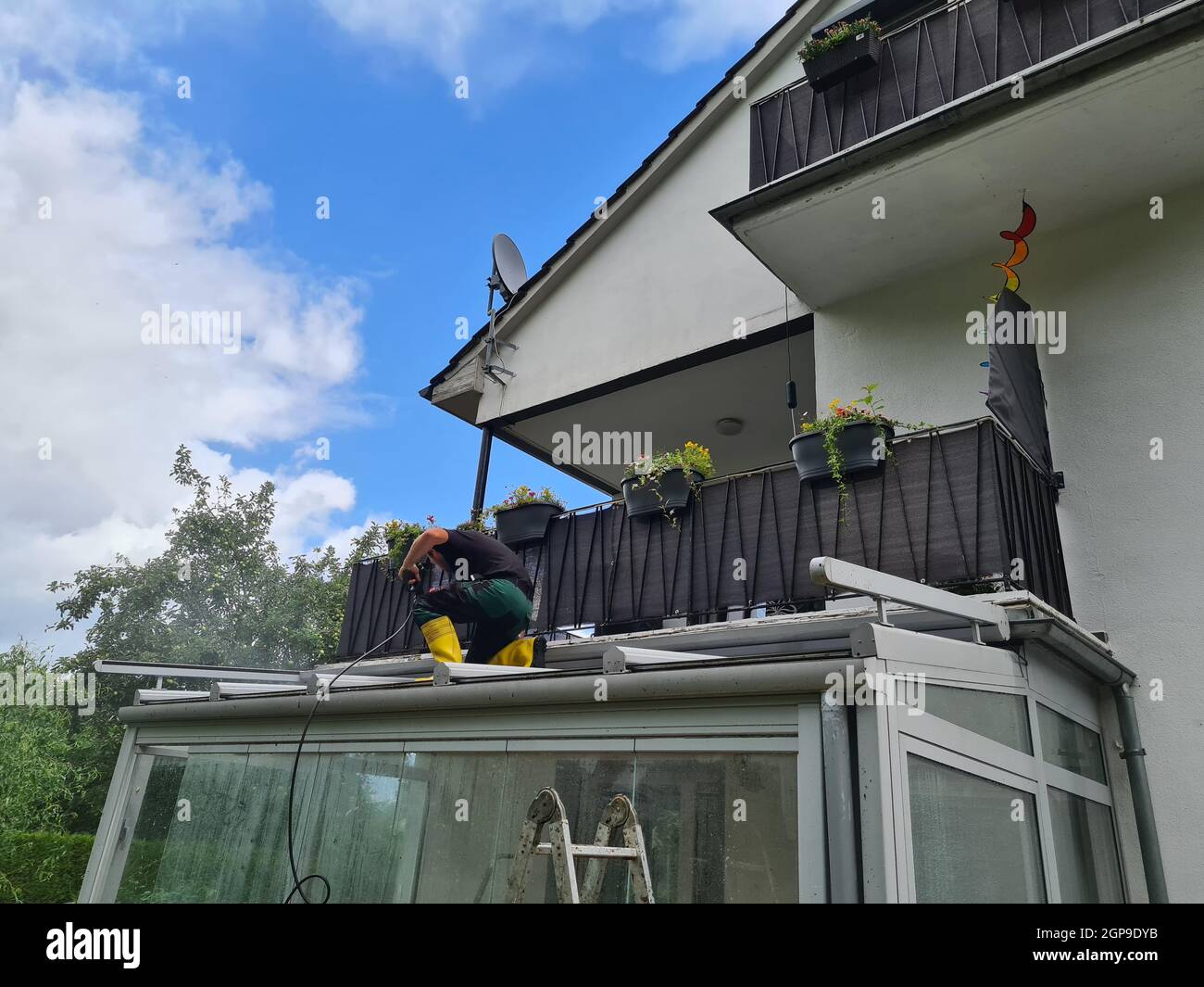 Man power washing conservatory roof and windows Stock Photo - Alamy