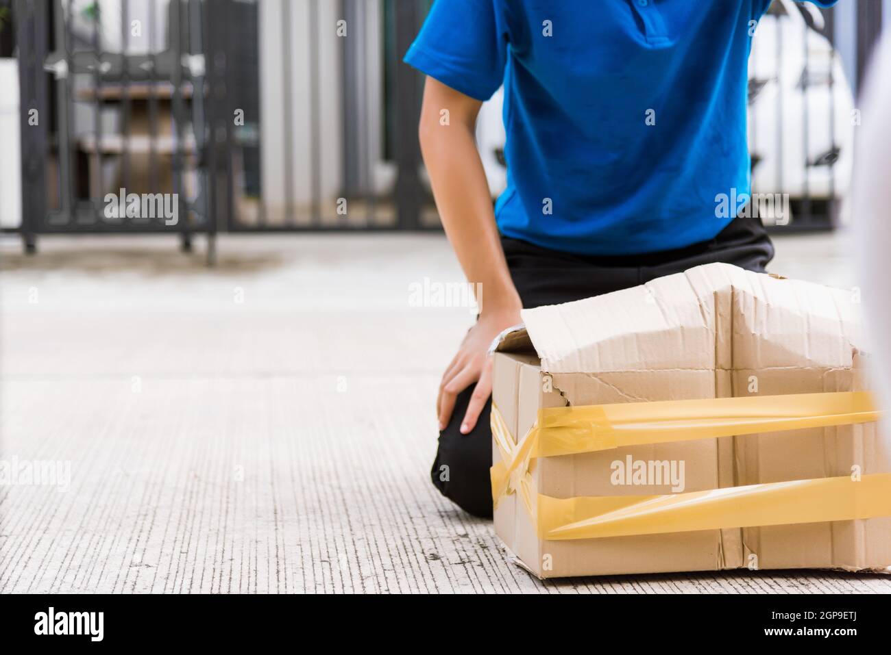 Asian young delivery man in blue uniform he emotional falling courier ...
