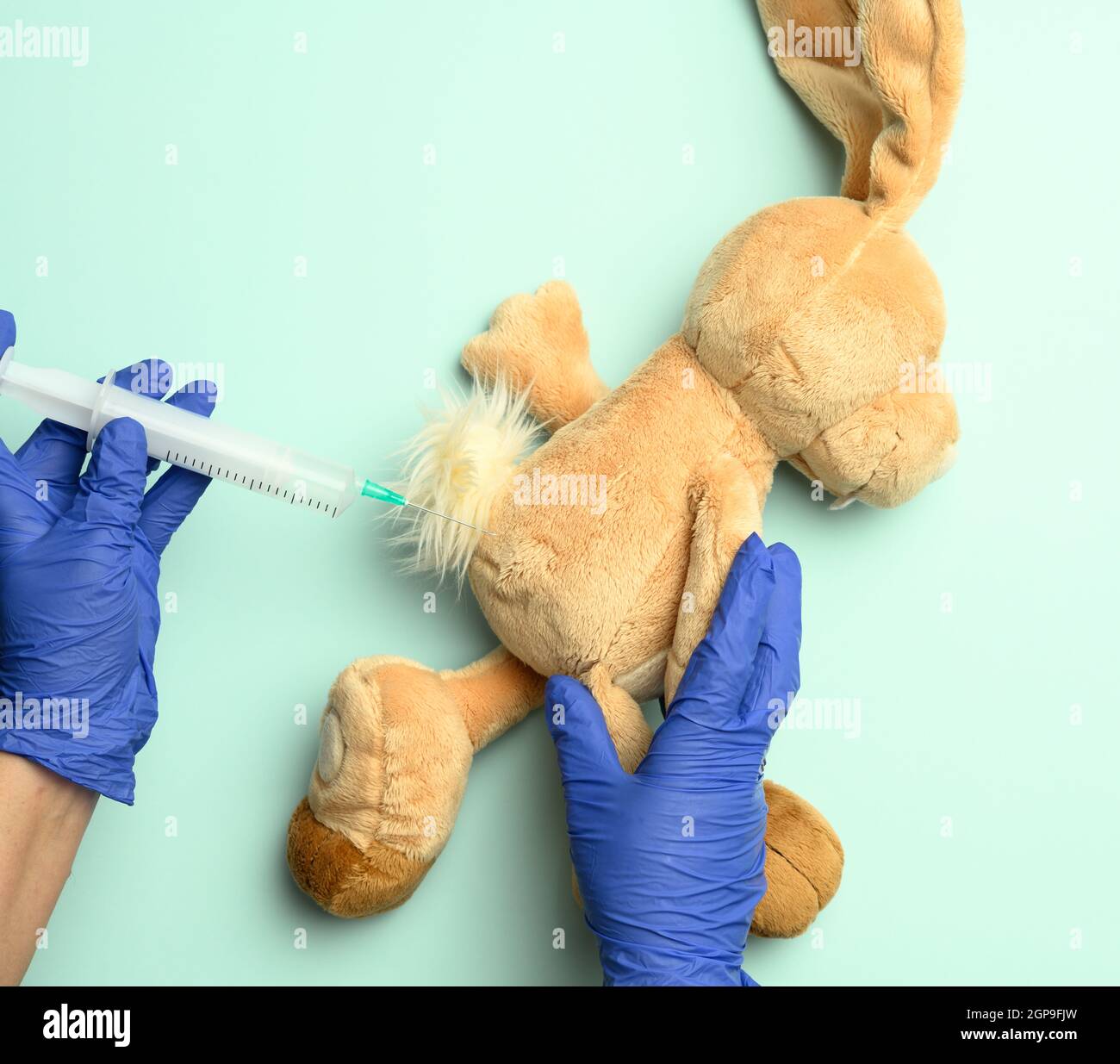 plush rabbit and two female hands of a doctor injecting an injection on ...