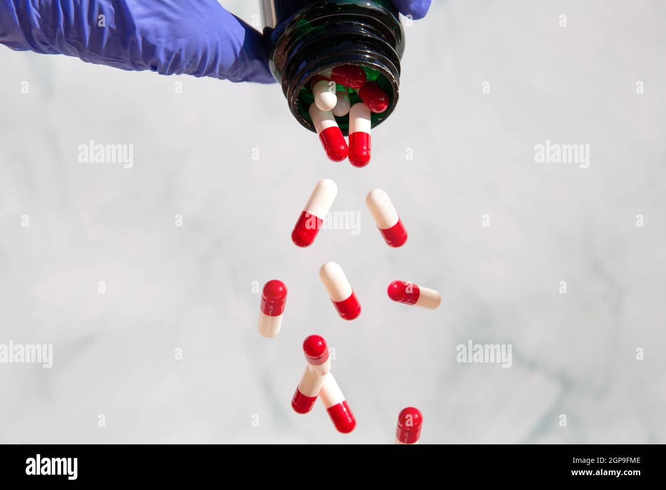 A hand grabbing pharmacy jars full of medicines, Capsules falling out ...