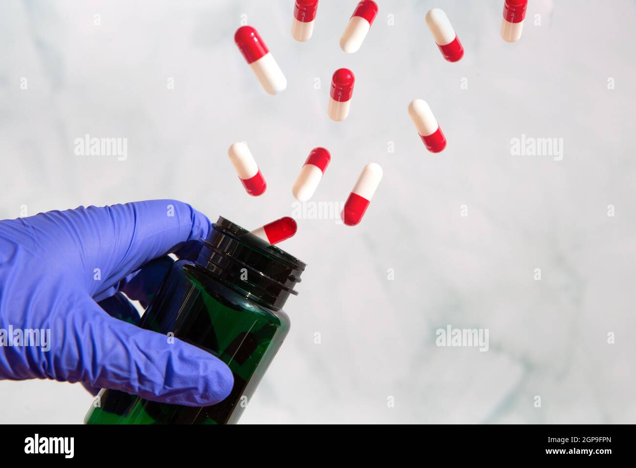 A hand grabbing pharmacy jars full of medicines, Capsules falling out ...