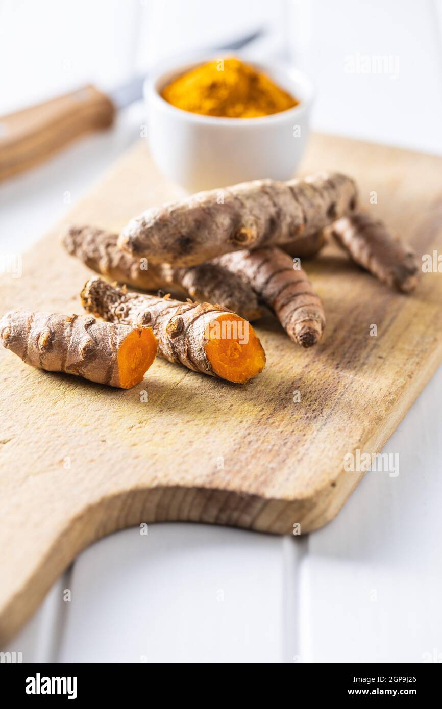 Indian turmeric root and powder. Turmeric spice on cutting board Stock ...