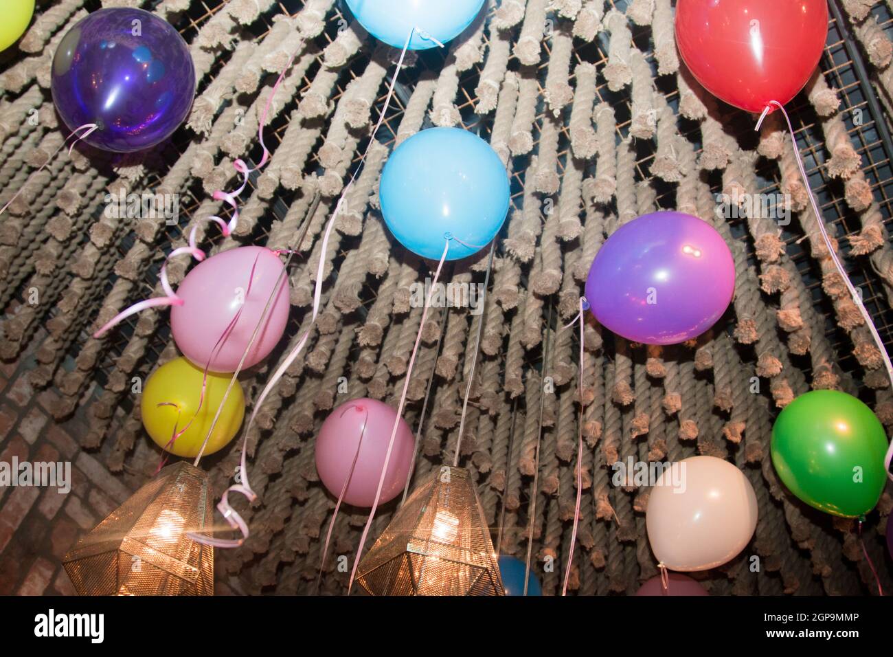 Colorful festive holiday party balloons floating flying under rope ...