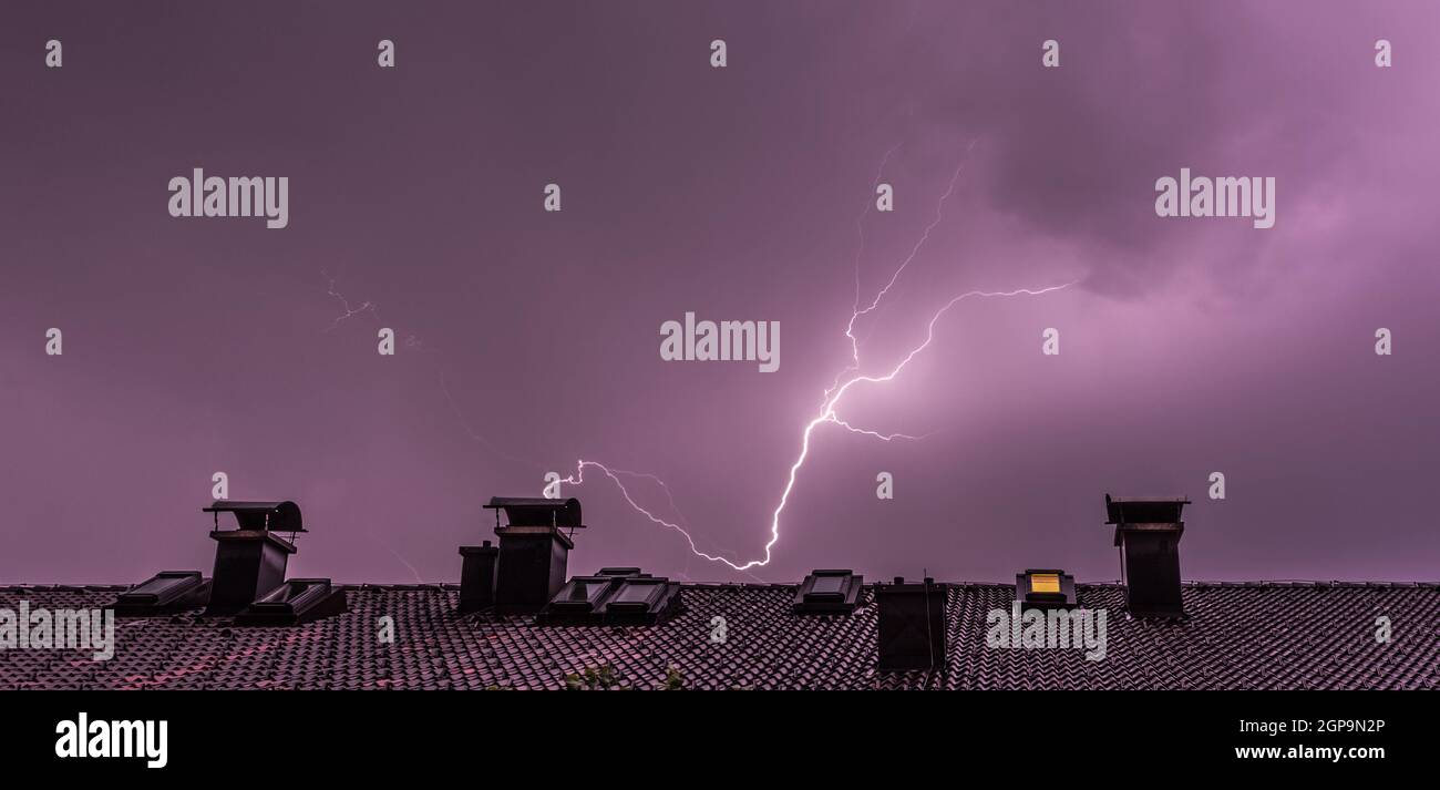 Lightning on the colored sky, roof of a building Stock Photo - Alamy