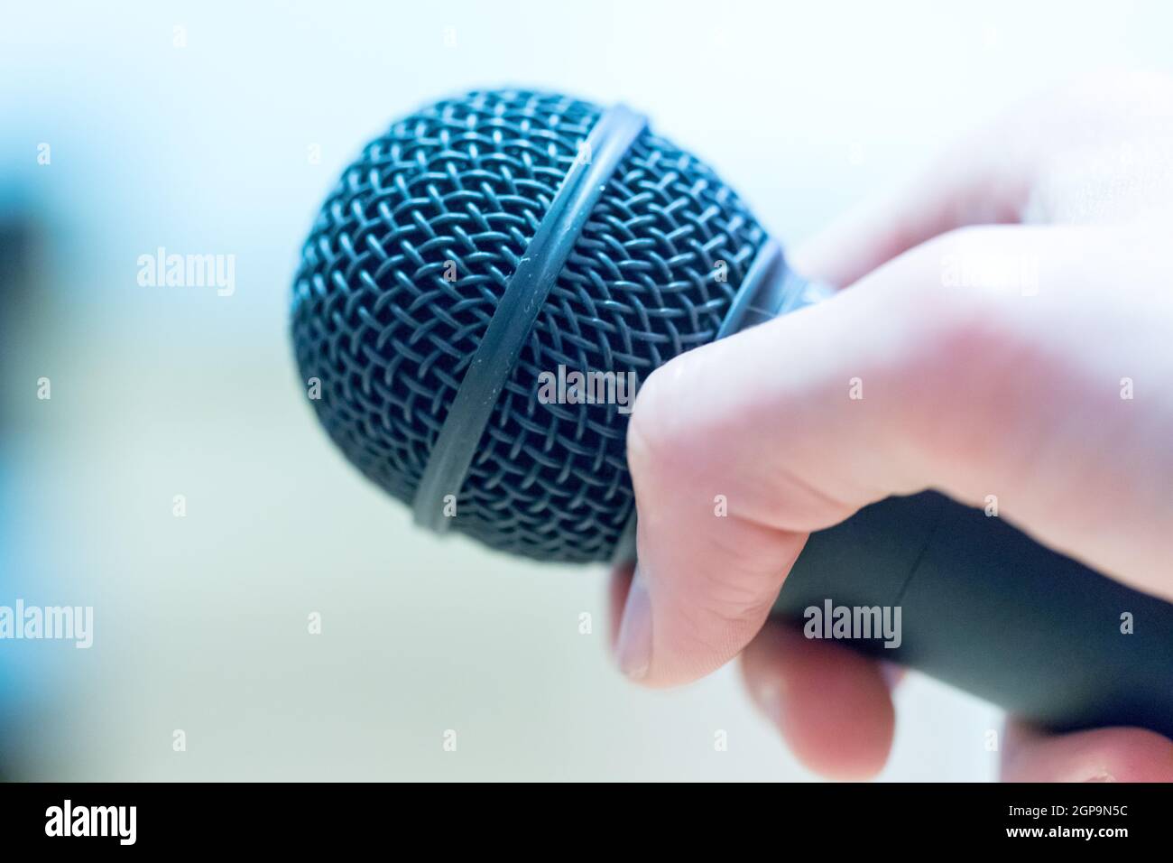 Close up picture of a hand which is holding a black microphone Stock ...