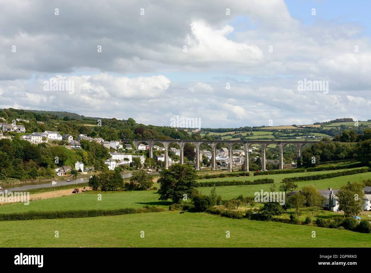 landscape of lush countryside with tall bridge crossing the river ...