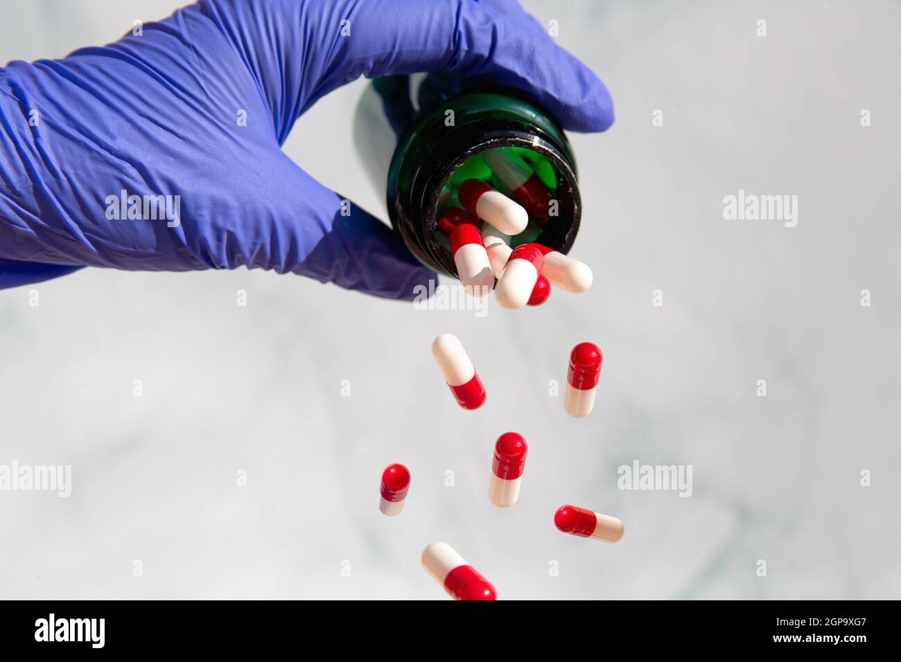 A hand grabbing pharmacy jars full of medicines, Capsules falling out ...