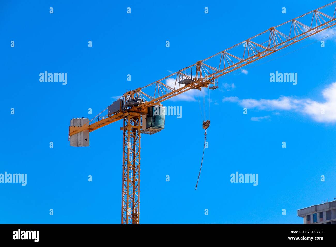 Tower building crane against the blue sky and sun. Construction of new ...