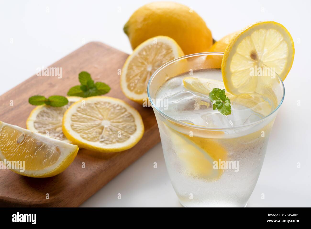 Cold lemonade placed on a white background, with lemons behind it Stock ...