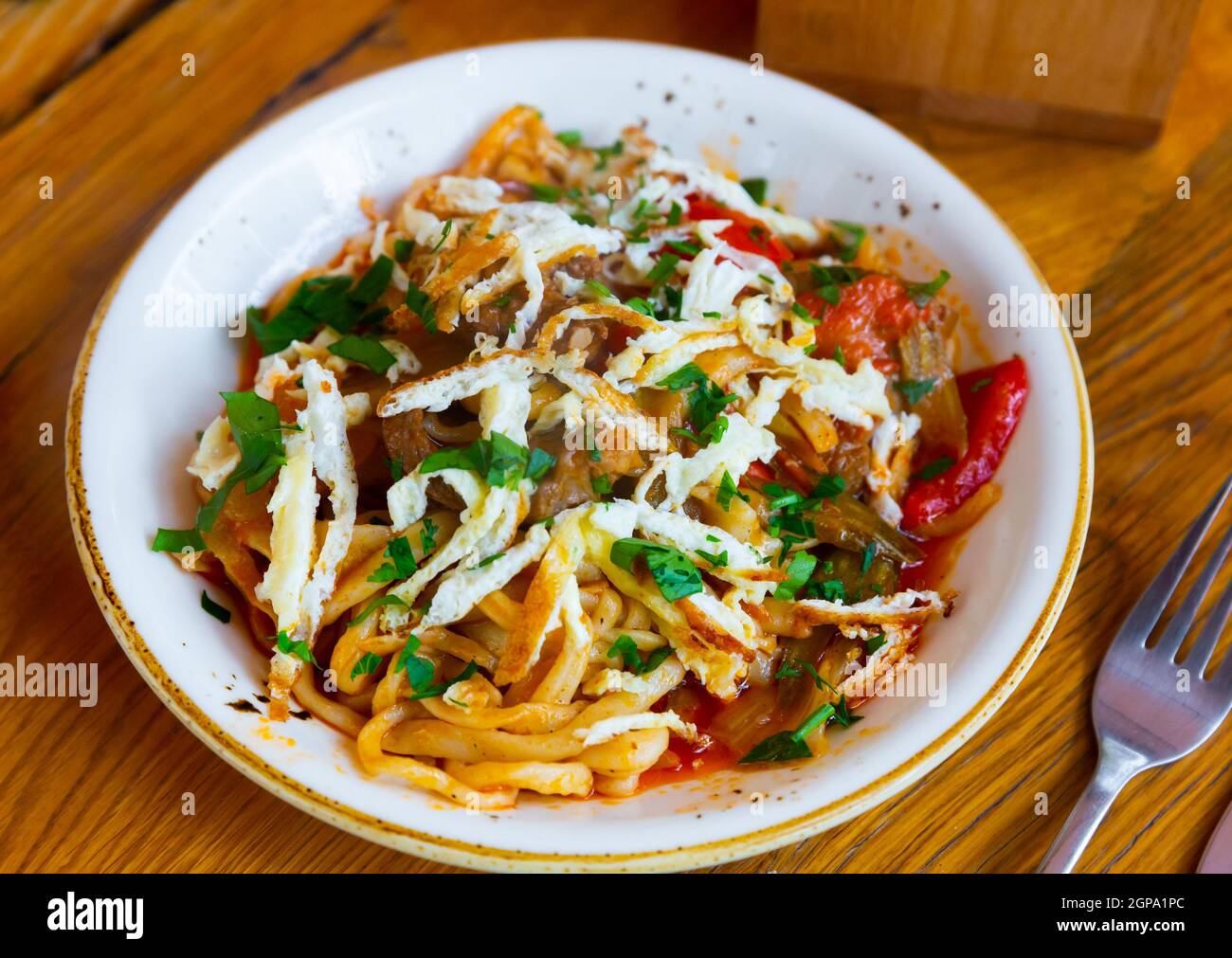 Traditional kaurma laghman noodles fried with vegetables, lamb and ...