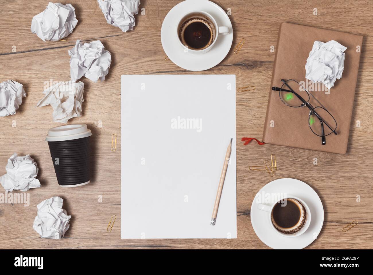 Crumpled papers scattered, empty cups of coffee on table of a creative ...