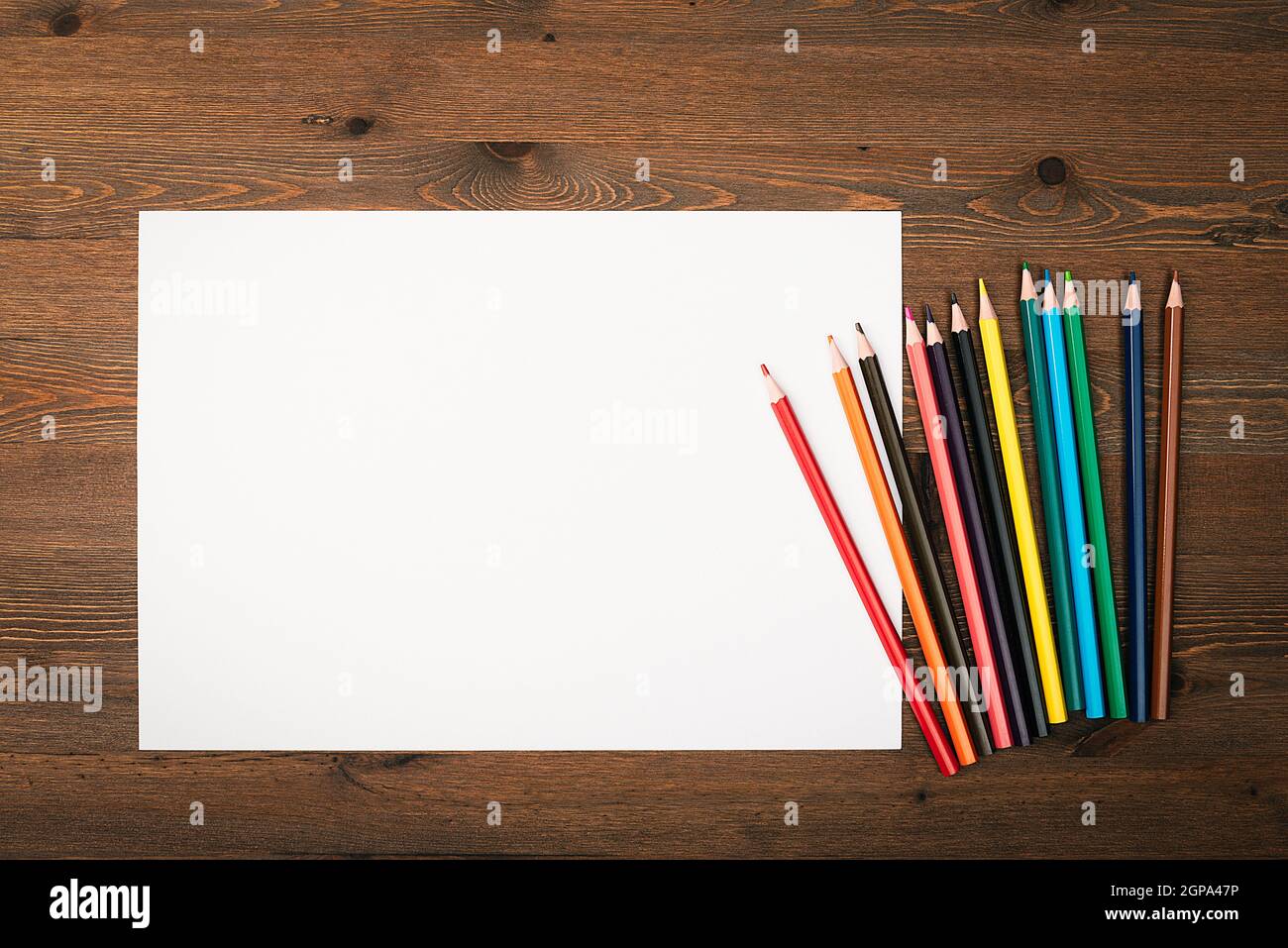 The sheet is pure white and colored pencils for drawing on a wooden ...