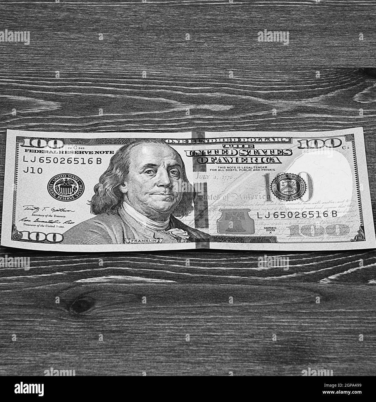 a hundred-dollar bill in cash on a dark wood table. Mockup, layout ...